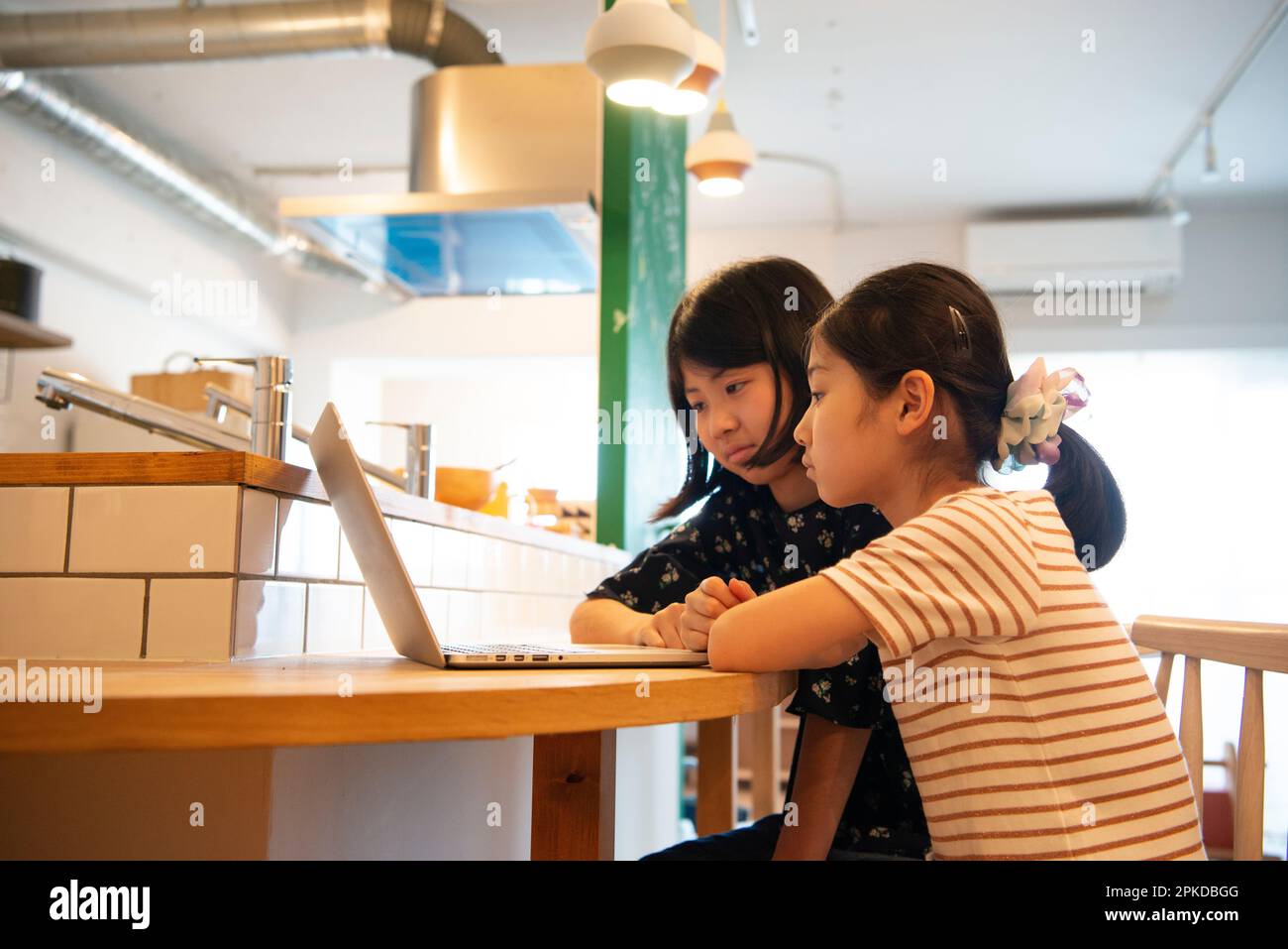 Sisters looking at a computer screen Stock Photo - Alamy