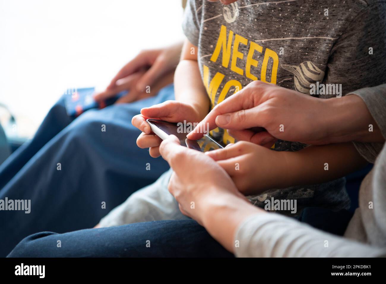 Child and parent holding a smart phone Stock Photo - Alamy