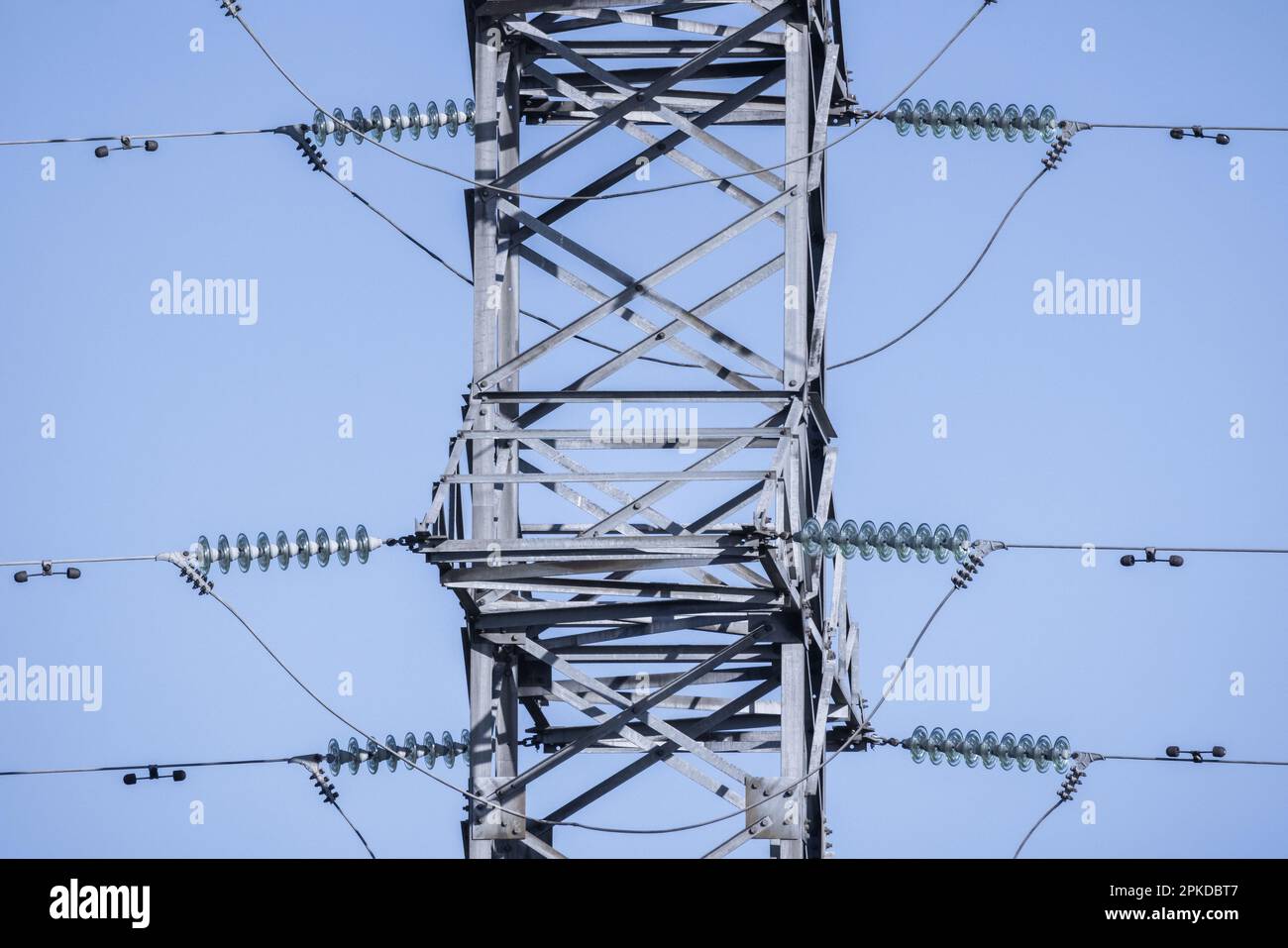 Lattice-type steel tower is under blue sky as a part of high-voltage ...