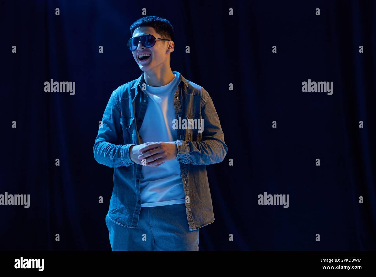 Happy, delightful, positive young guy in casual clothes and sunglasses ...
