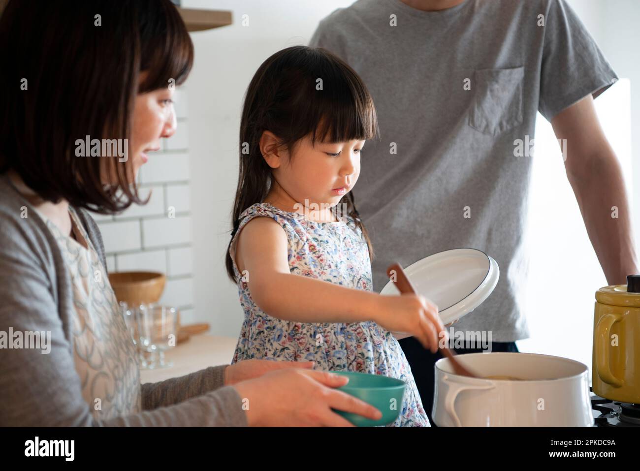 Girl and her parents helping in the kitchen Stock Photo - Alamy