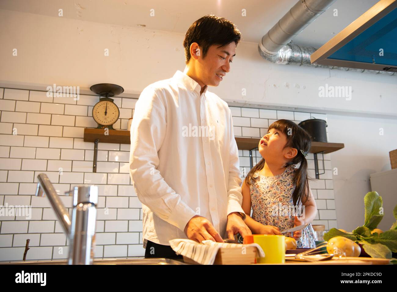 Girl and her father helping in the kitchen Stock Photo - Alamy
