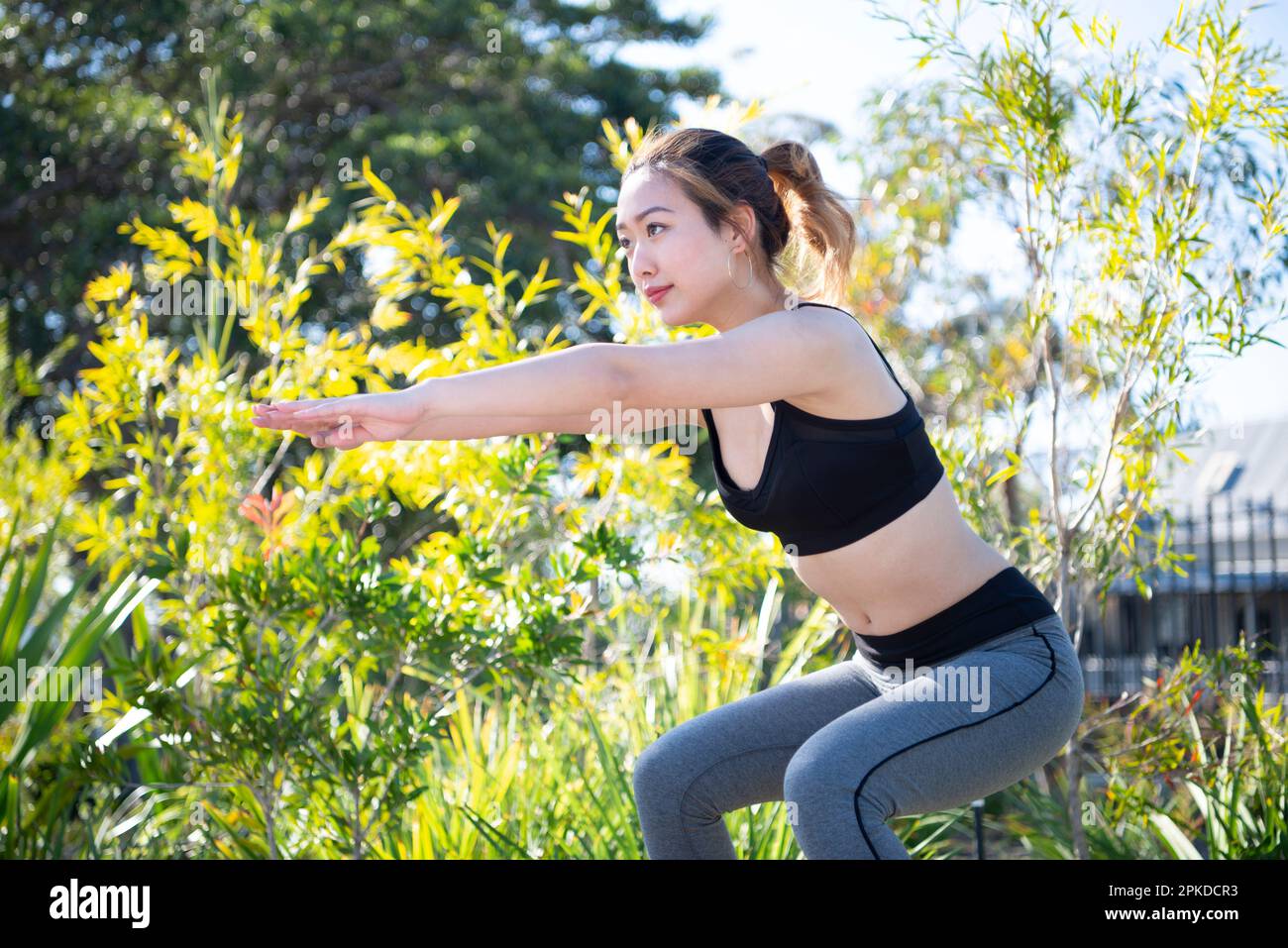 Woman doing squats in training clothes Stock Photo - Alamy