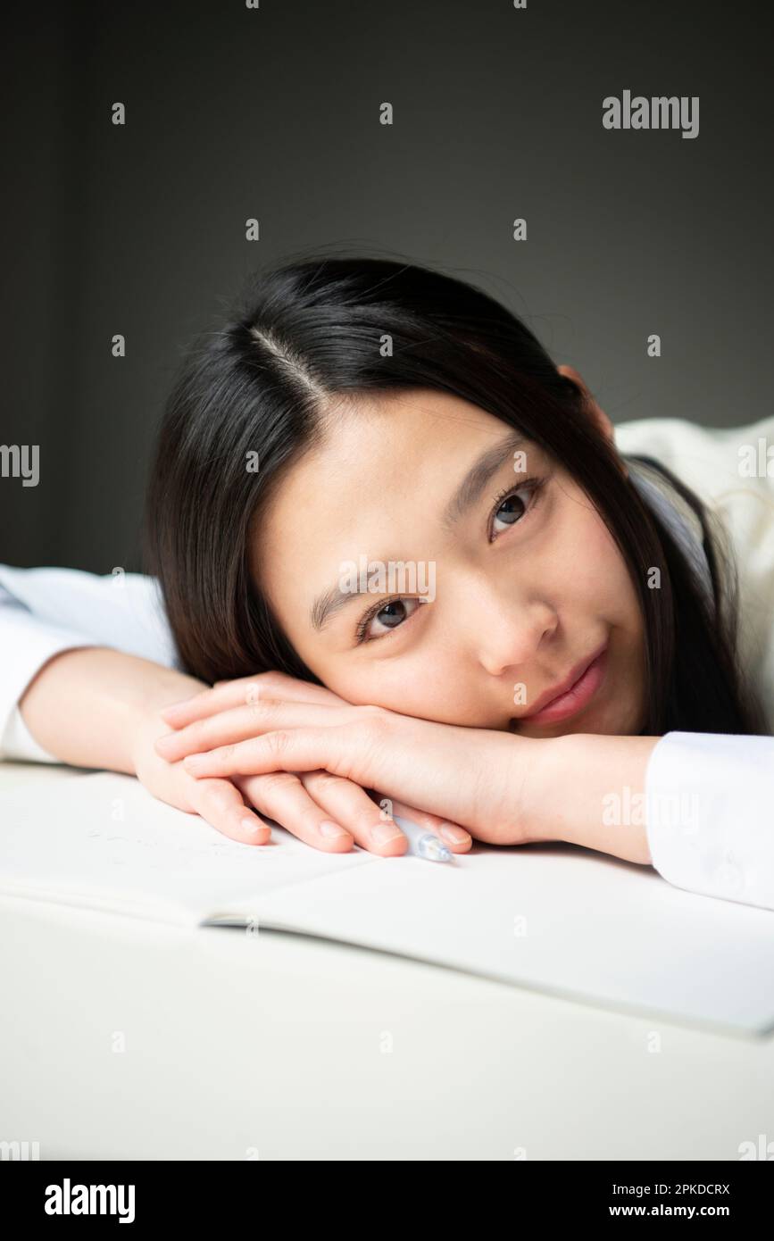 High school girl lying down on a desk Stock Photo - Alamy