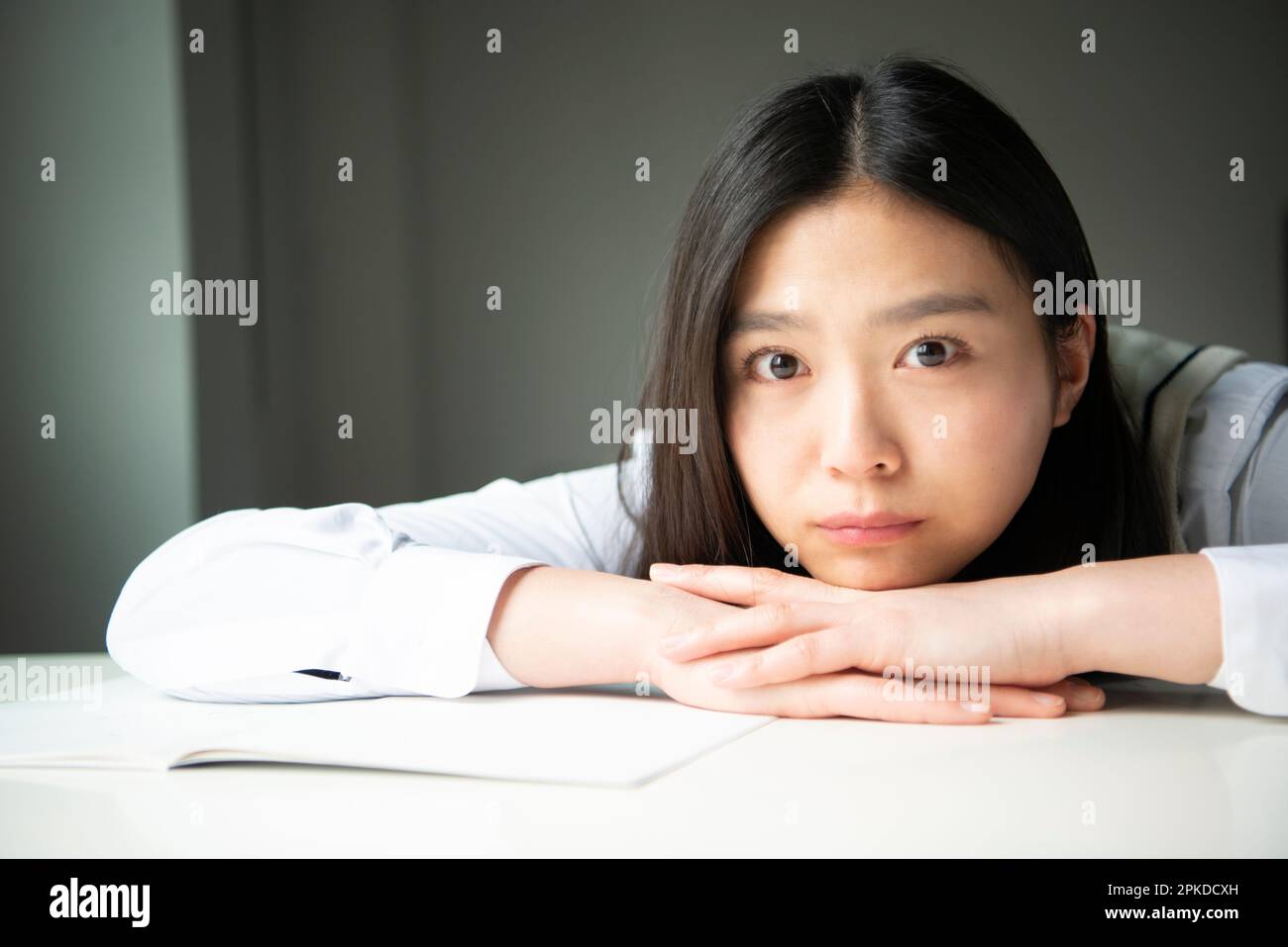 High school girl lying down on a desk Stock Photo - Alamy