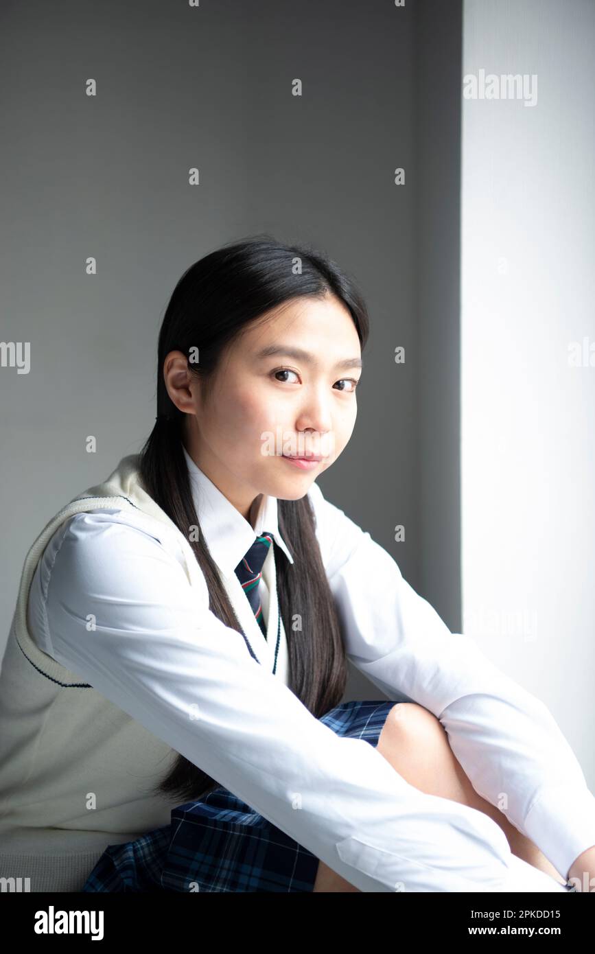 High school girl sitting and looking at you Stock Photo - Alamy