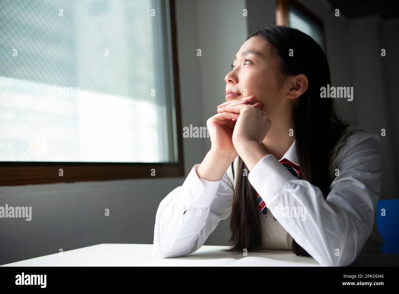 High school girl looking out the window Stock Photo - Alamy