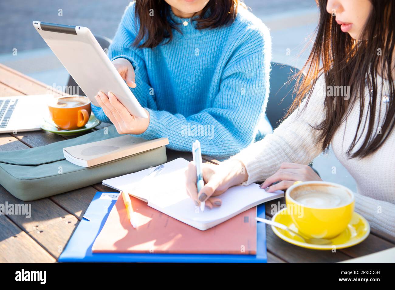 Two people studying while looking at a tablet Stock Photo - Alamy