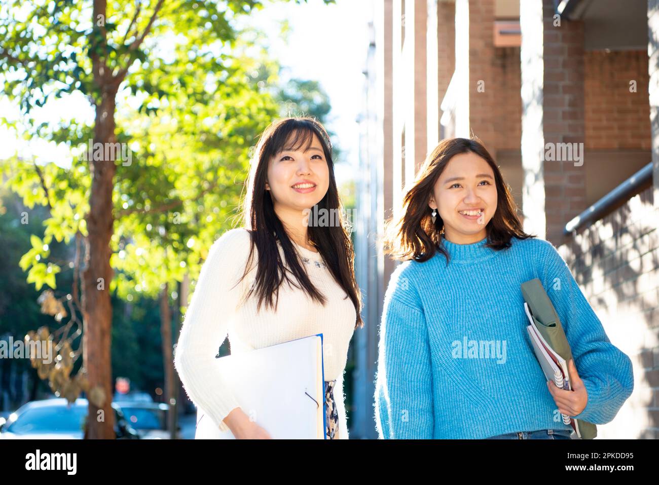 Two people holding notebooks etc Stock Photo - Alamy