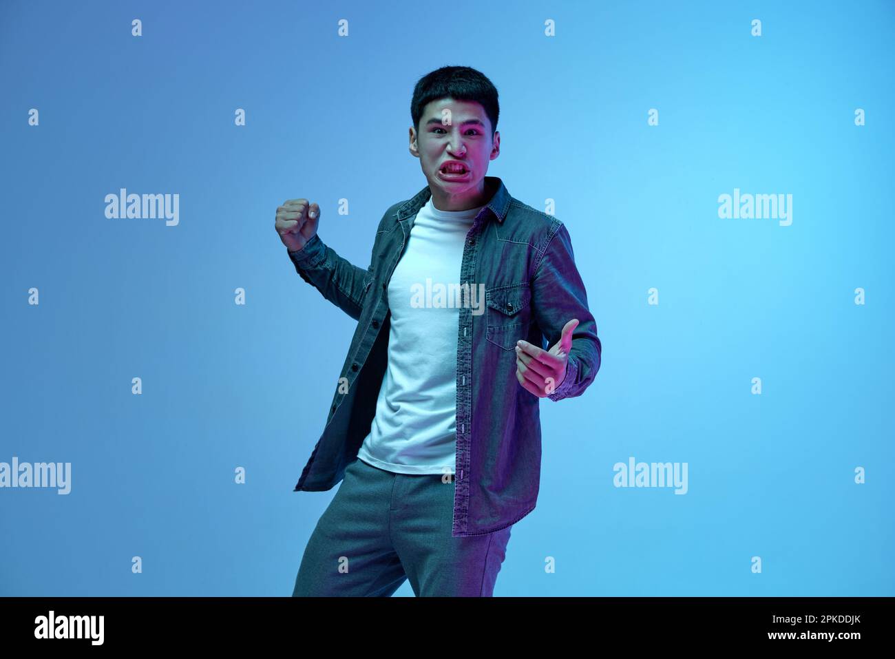 Young guy in casual clothes showing anger and irritation with fists and ...