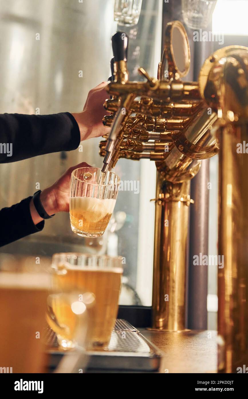 Side view of man's hands that fills glasses by beer Stock Photo - Alamy