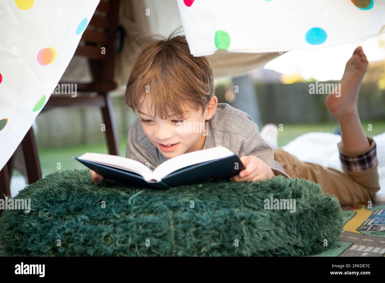 Boy reading a book in a tent made of sheets Stock Photo - Alamy