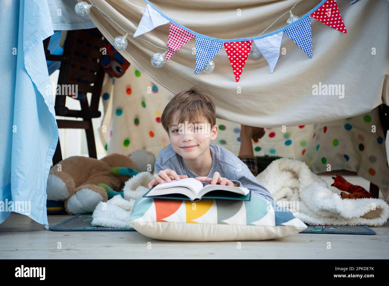 Boy reading a book in a tent made of sheets Stock Photo - Alamy