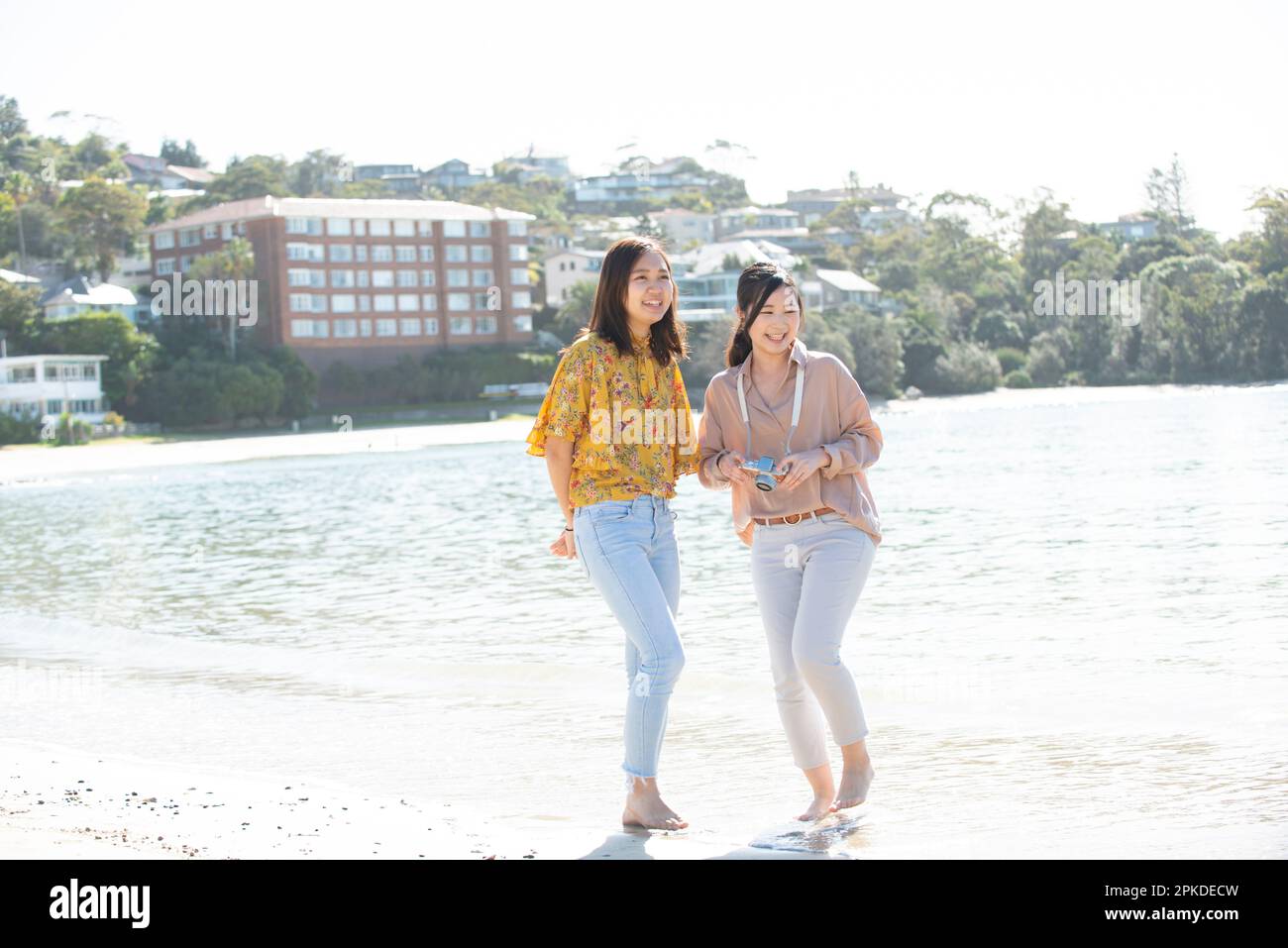 2 women laughing on the beach Stock Photo - Alamy