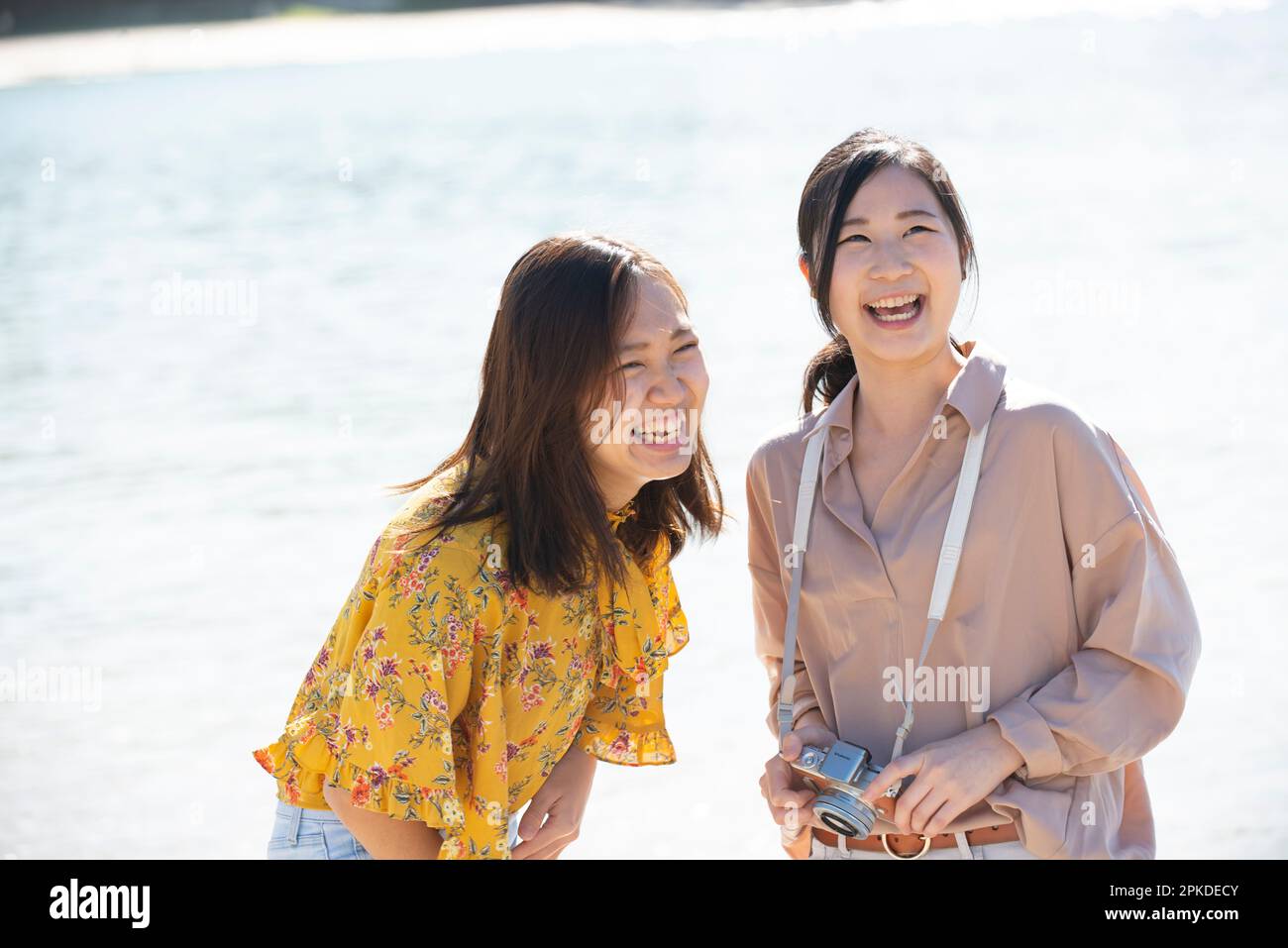 2 women laughing on the beach Stock Photo - Alamy