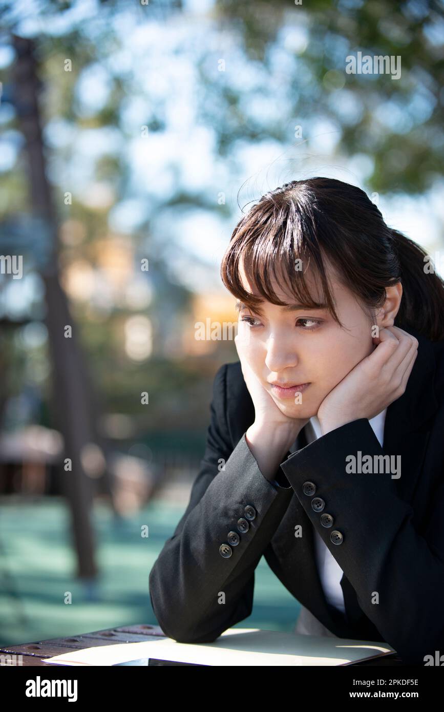 A woman in a suit, pondering Stock Photo - Alamy