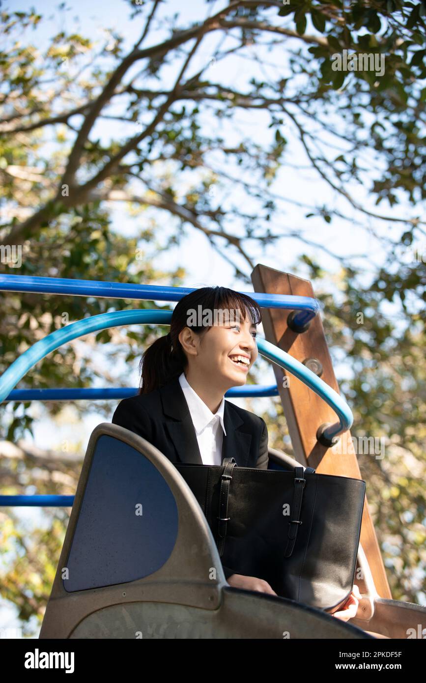 Woman in suit laughing on the slide Stock Photo - Alamy