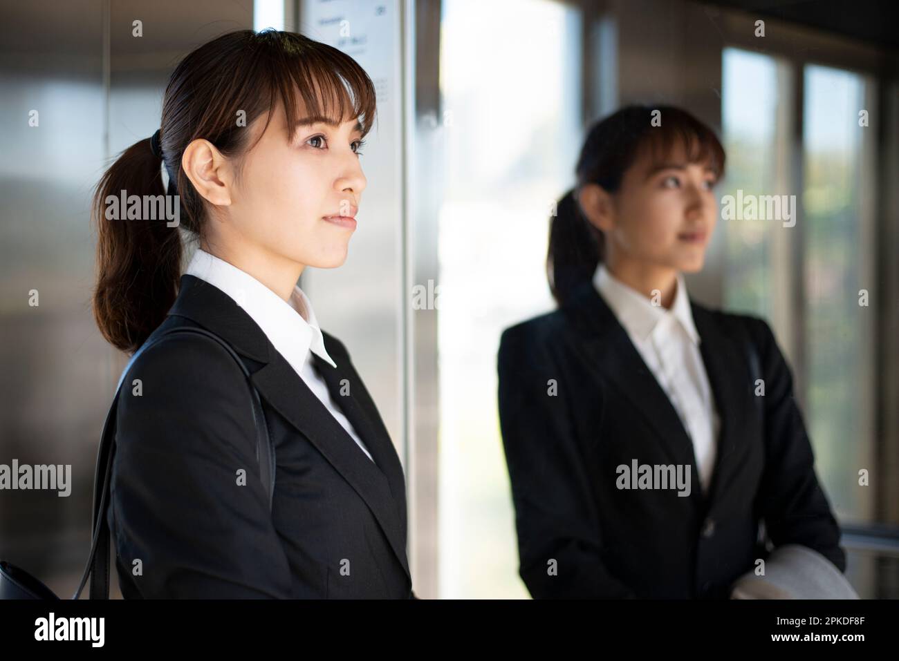 Woman in suit riding in elevator Stock Photo - Alamy