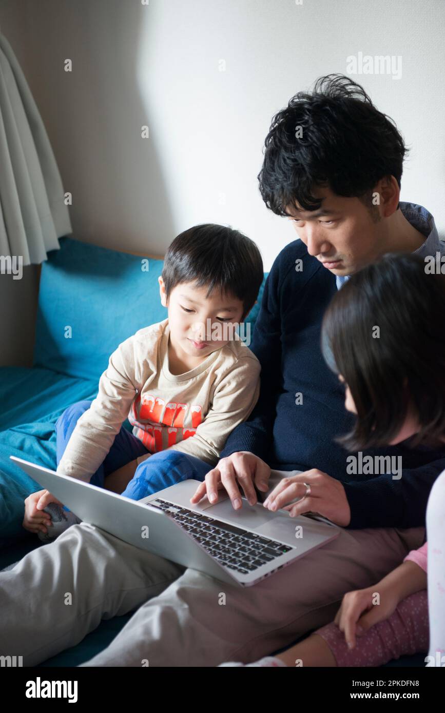 Father and children looking at a computer screen Stock Photo - Alamy
