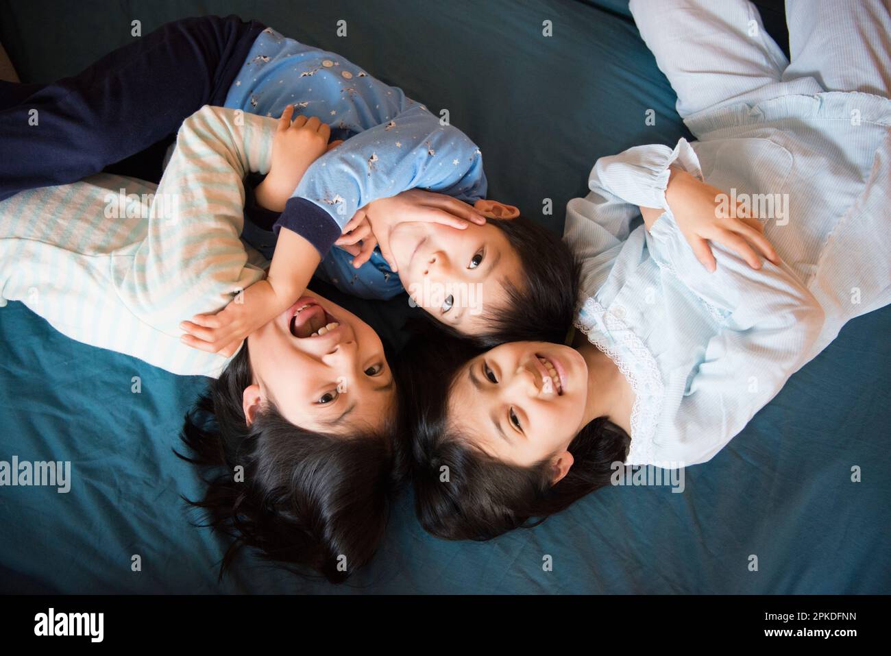Children lying on bed Stock Photo - Alamy