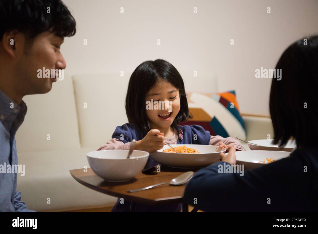 Girl having dinner with family Stock Photo - Alamy