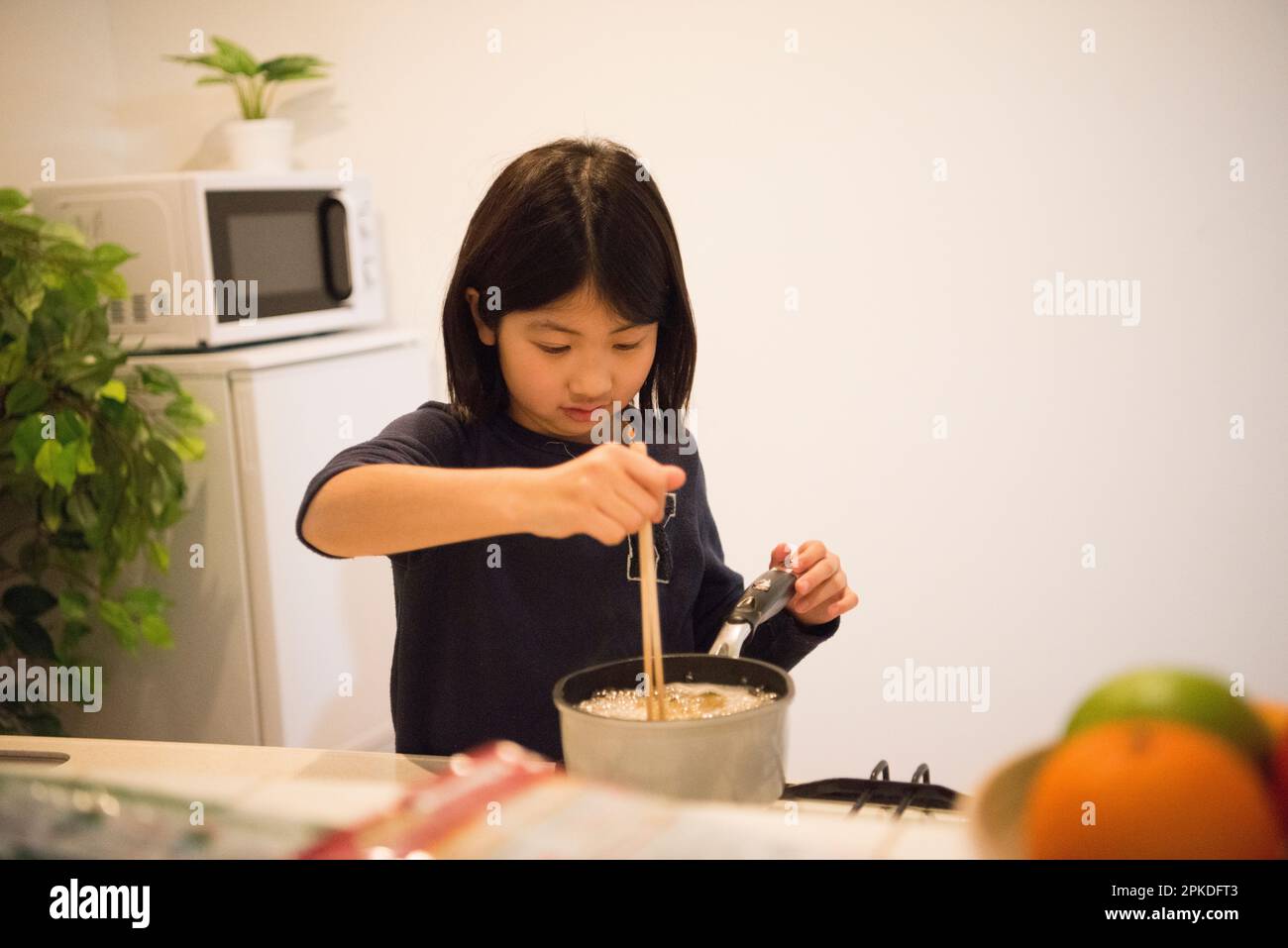 Girl cooking in kitchen Stock Photo - Alamy