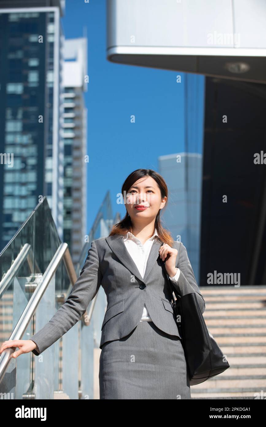 Woman in suit descending stairs Stock Photo - Alamy