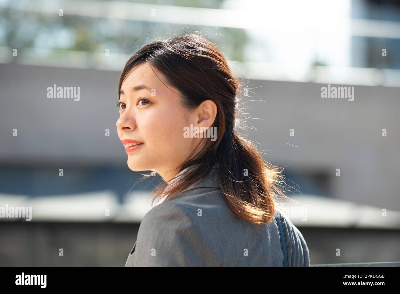 Woman in suit looking back Stock Photo - Alamy