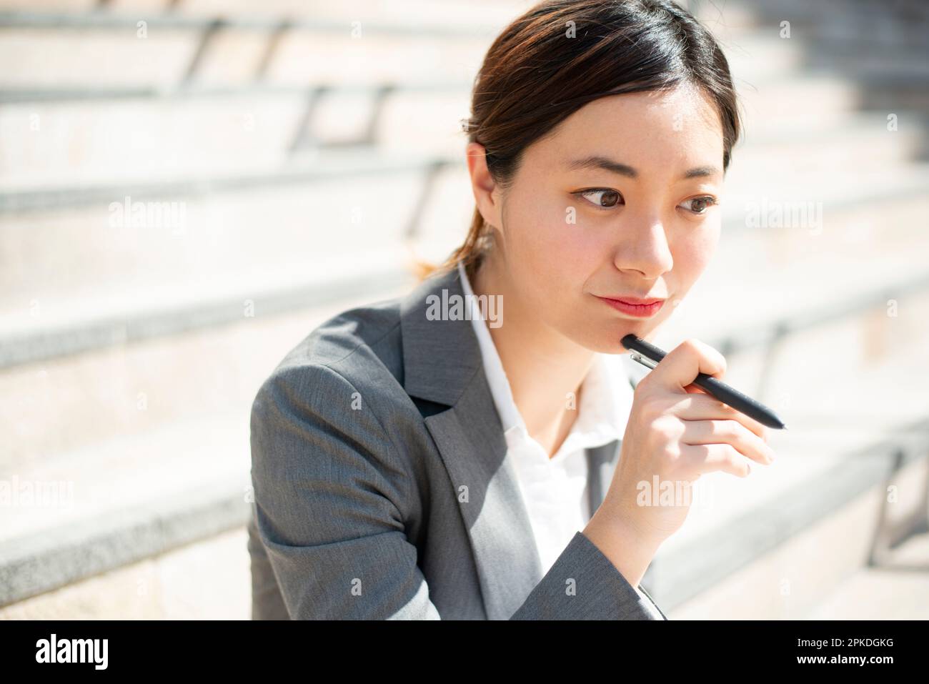 Woman thinking holding pen hi-res stock photography and images - Alamy