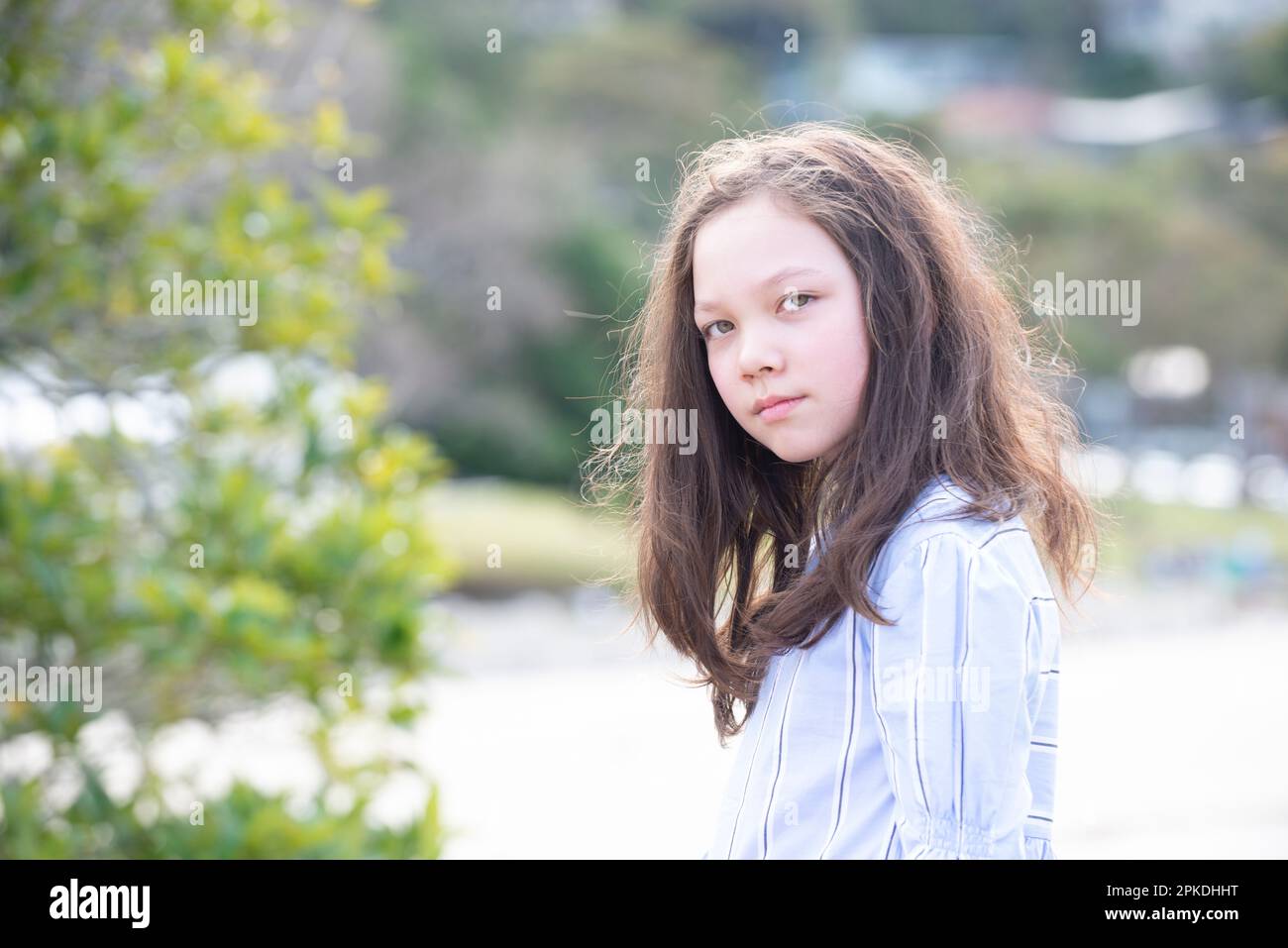 Half Girl standing next to a tree Stock Photo - Alamy