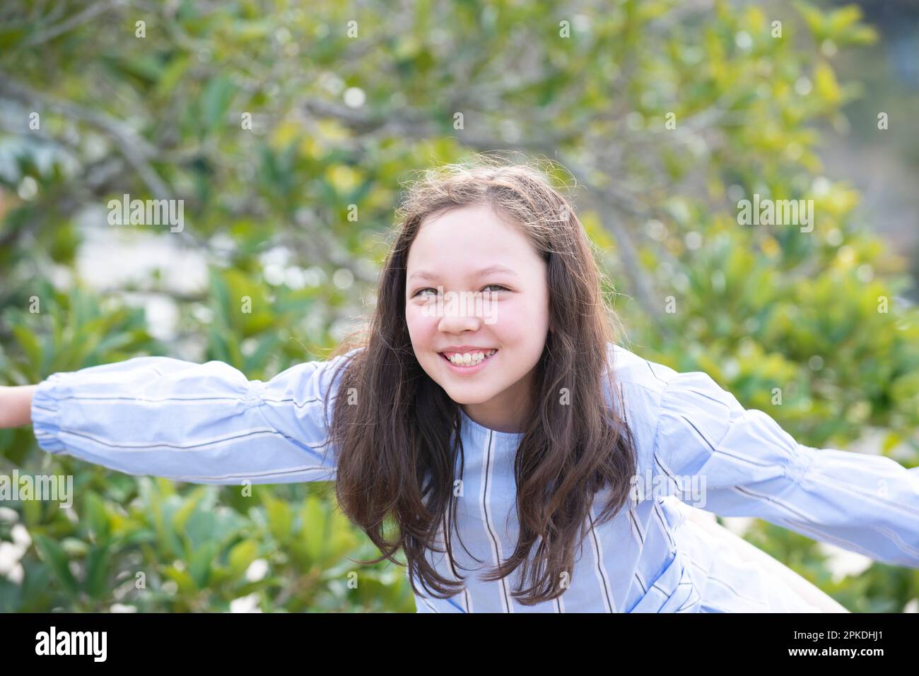 Half-girl laughing in front of green Stock Photo - Alamy