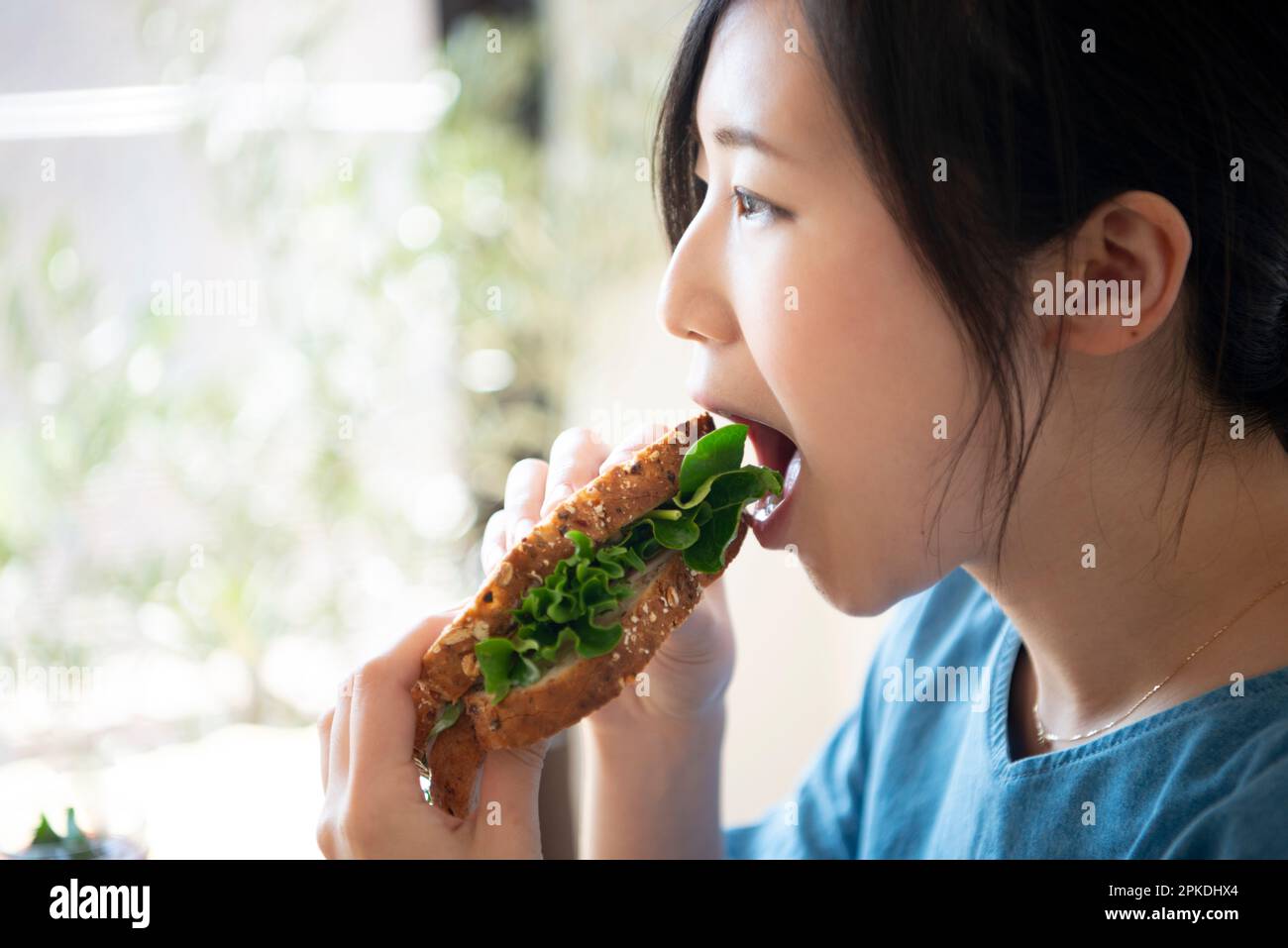 Woman eating a sandwich Stock Photo - Alamy
