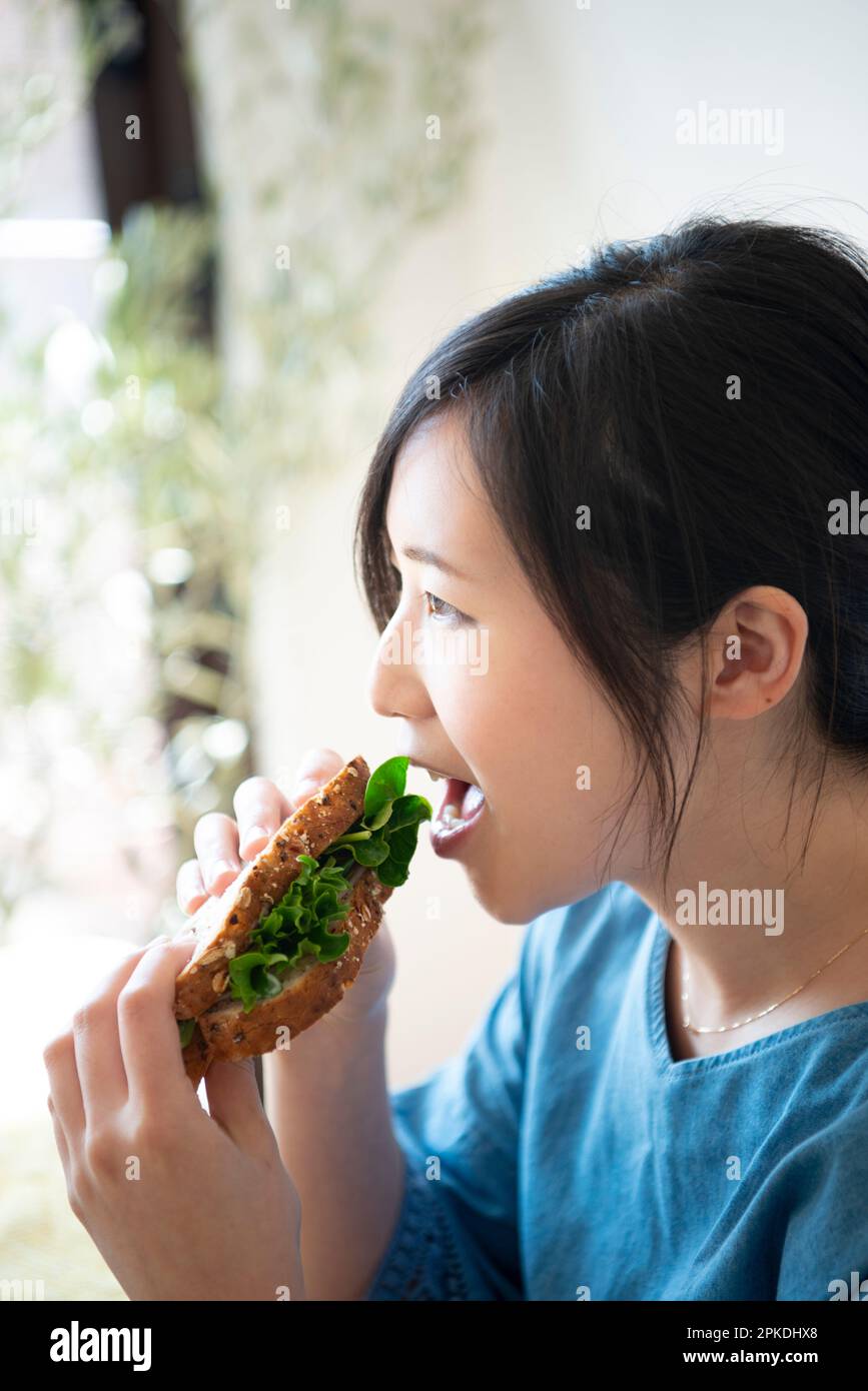 Woman eating a sandwich Stock Photo - Alamy