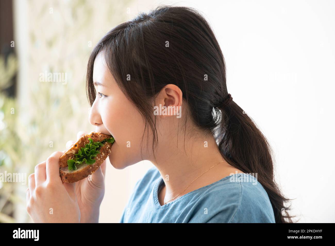 Woman eating a sandwich Stock Photo - Alamy