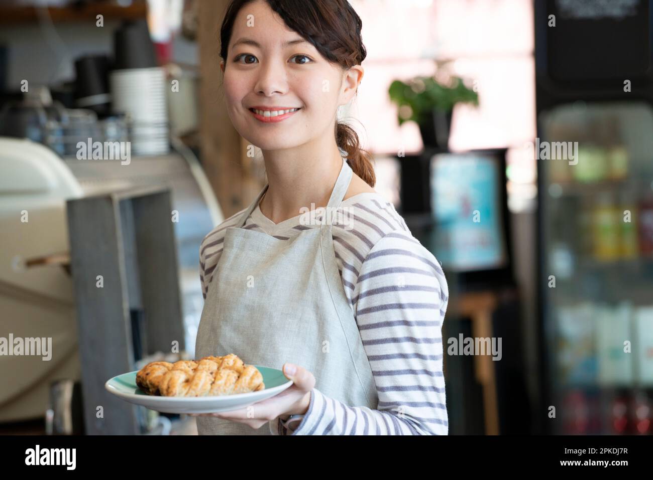 The woman of the shopkeeper laughing with the bread Stock Photo - Alamy