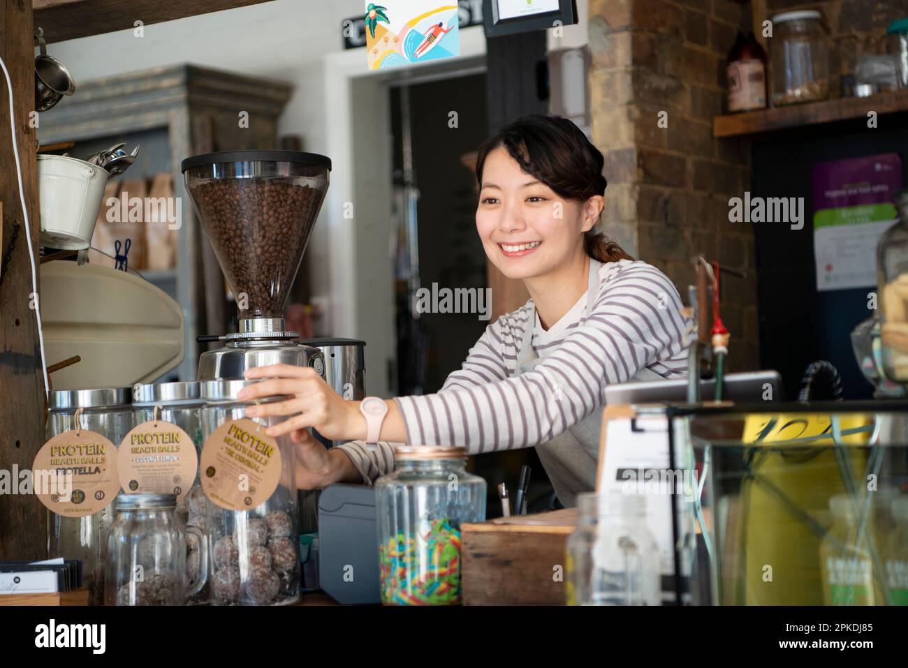 Smiling female waitress working in a café Stock Photo - Alamy