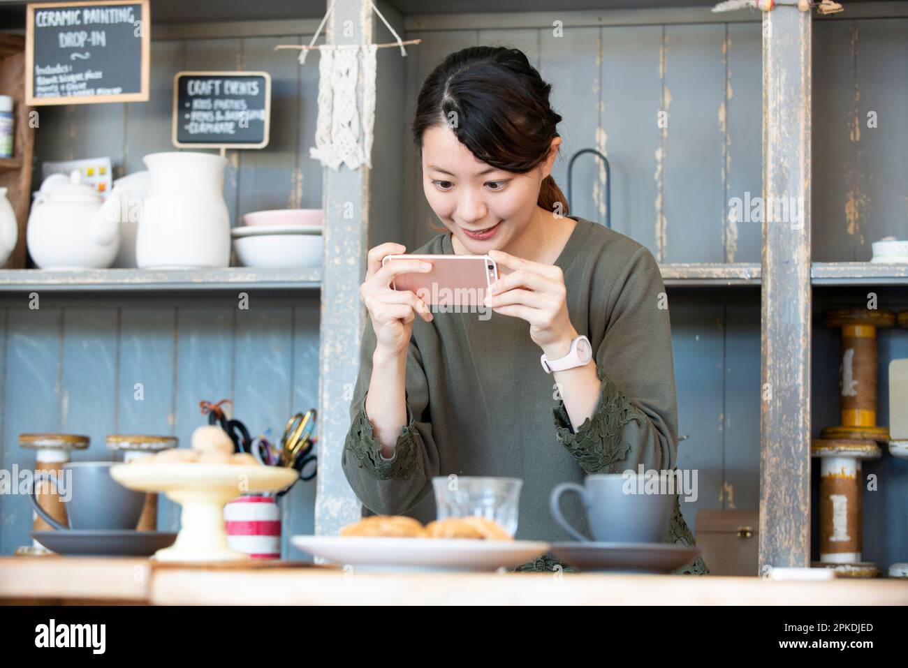 Woman taking a picture of sweets using her smartphone at a café Stock Photo - Alamy