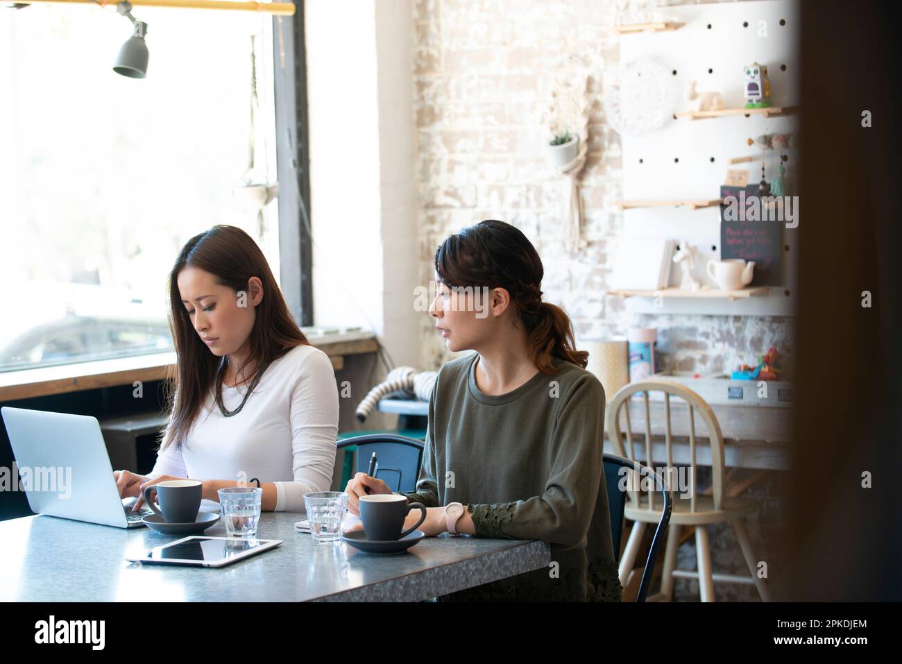 Two women working at a café Stock Photo - Alamy