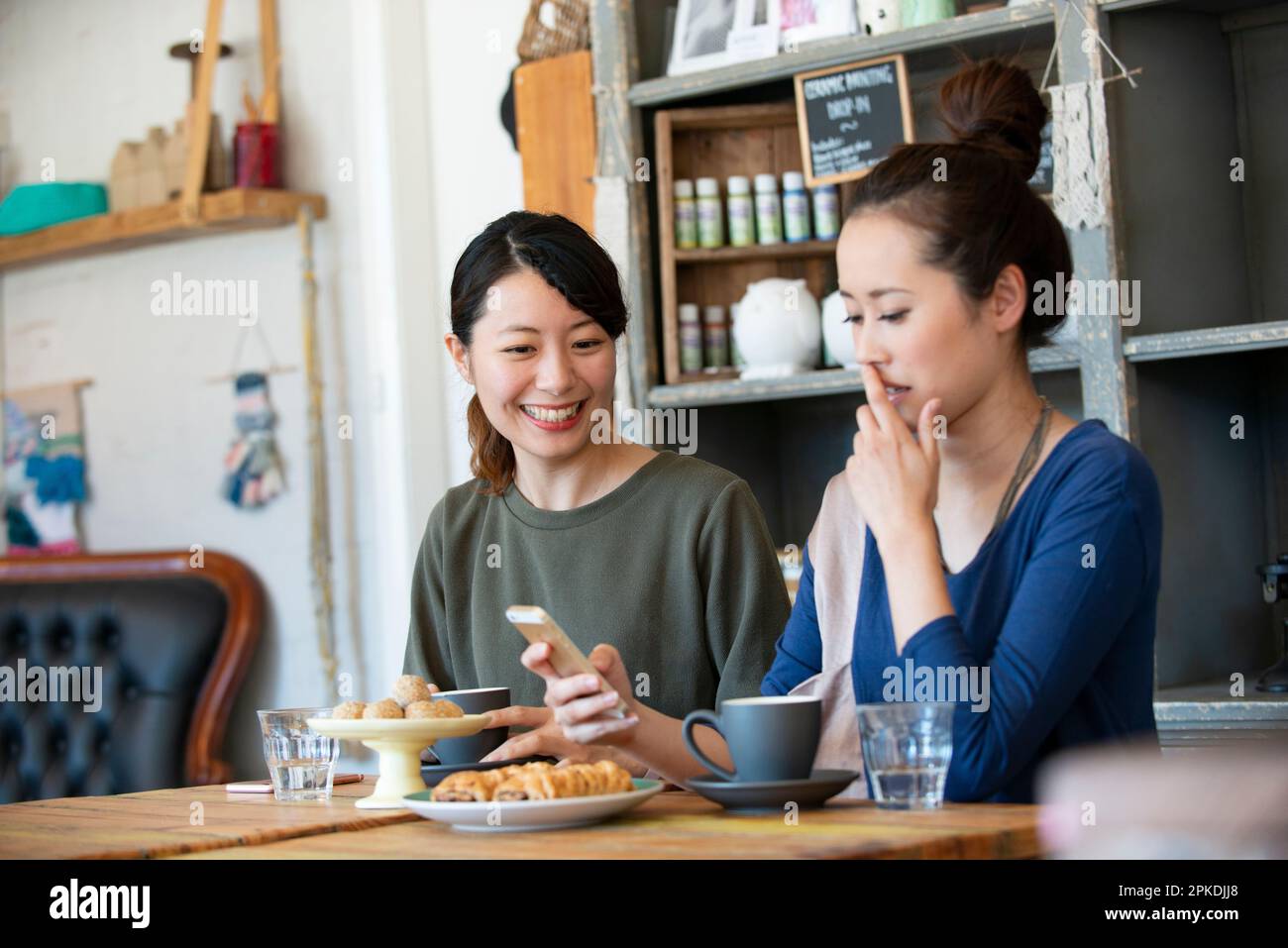 Two women enjoying sweets at a cafe Stock Photo - Alamy