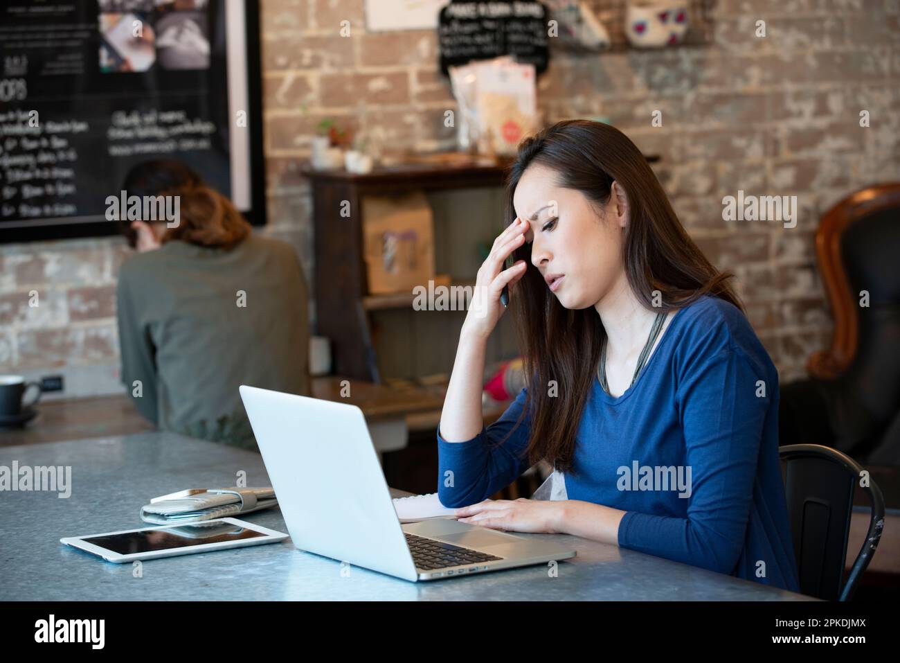 Woman thinking in front of a computer at a café Stock Photo - Alamy
