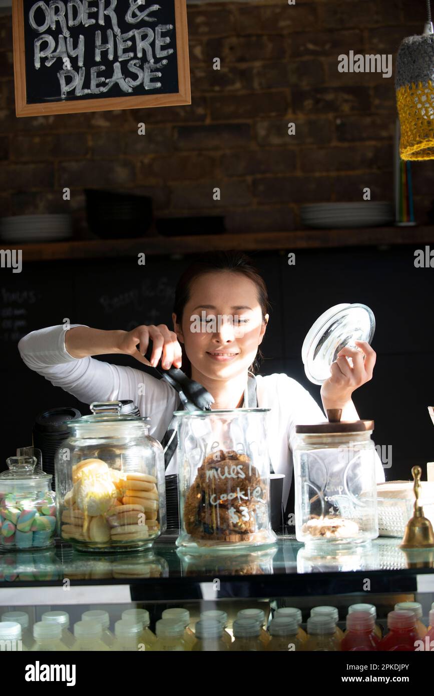 Female waitress working at a café Stock Photo - Alamy