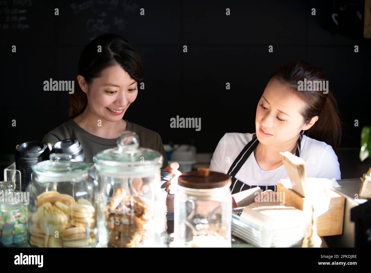 Two female waitresses working at a café Stock Photo - Alamy