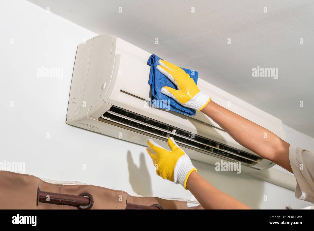Man cleaning outside air conditioner with clean cloth for good health ...