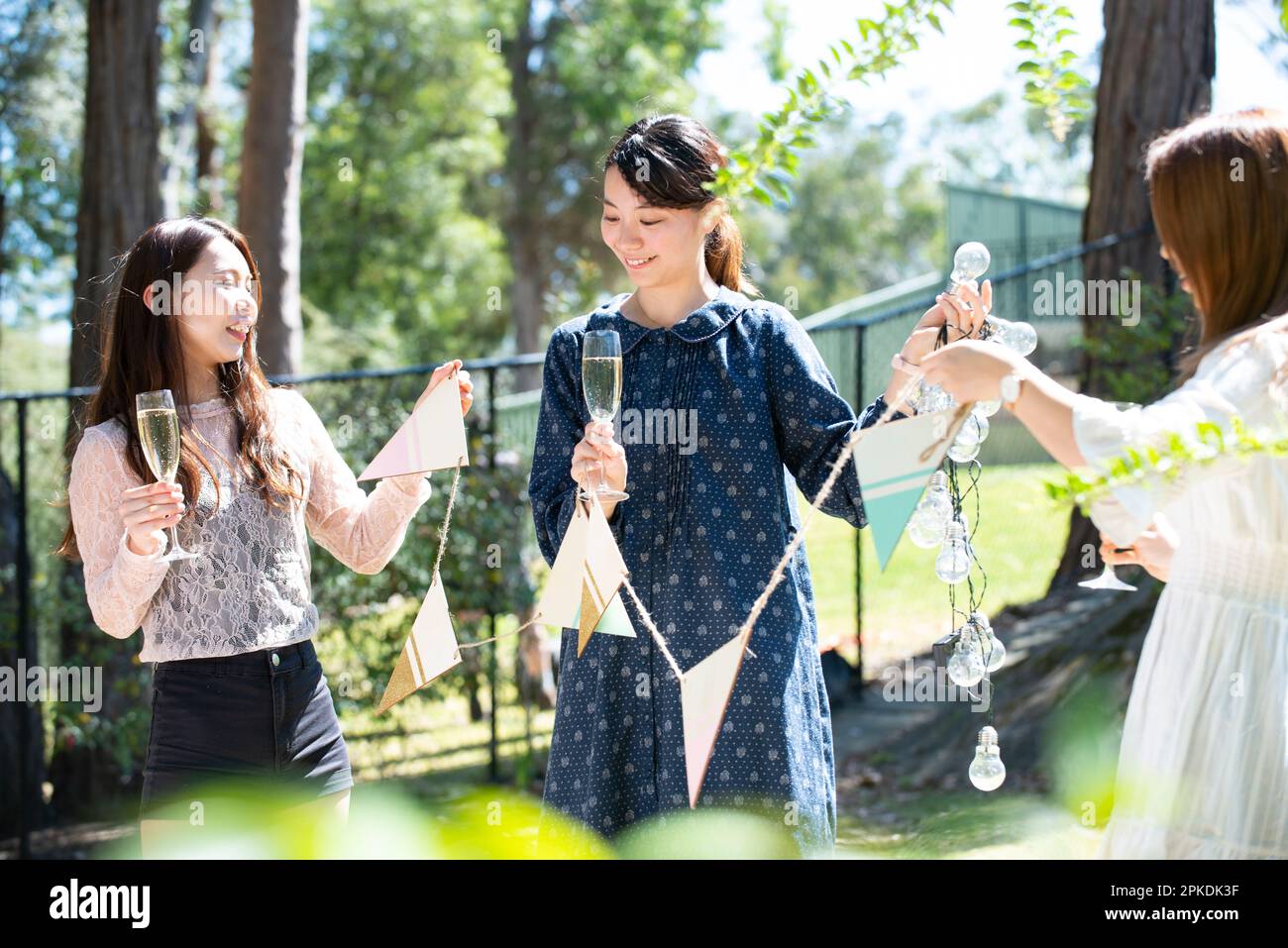 Three women decorating for a garden party Stock Photo - Alamy