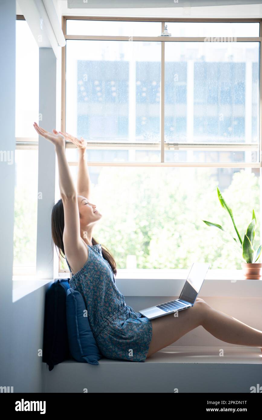 Woman stretching with computer on legs Stock Photo - Alamy