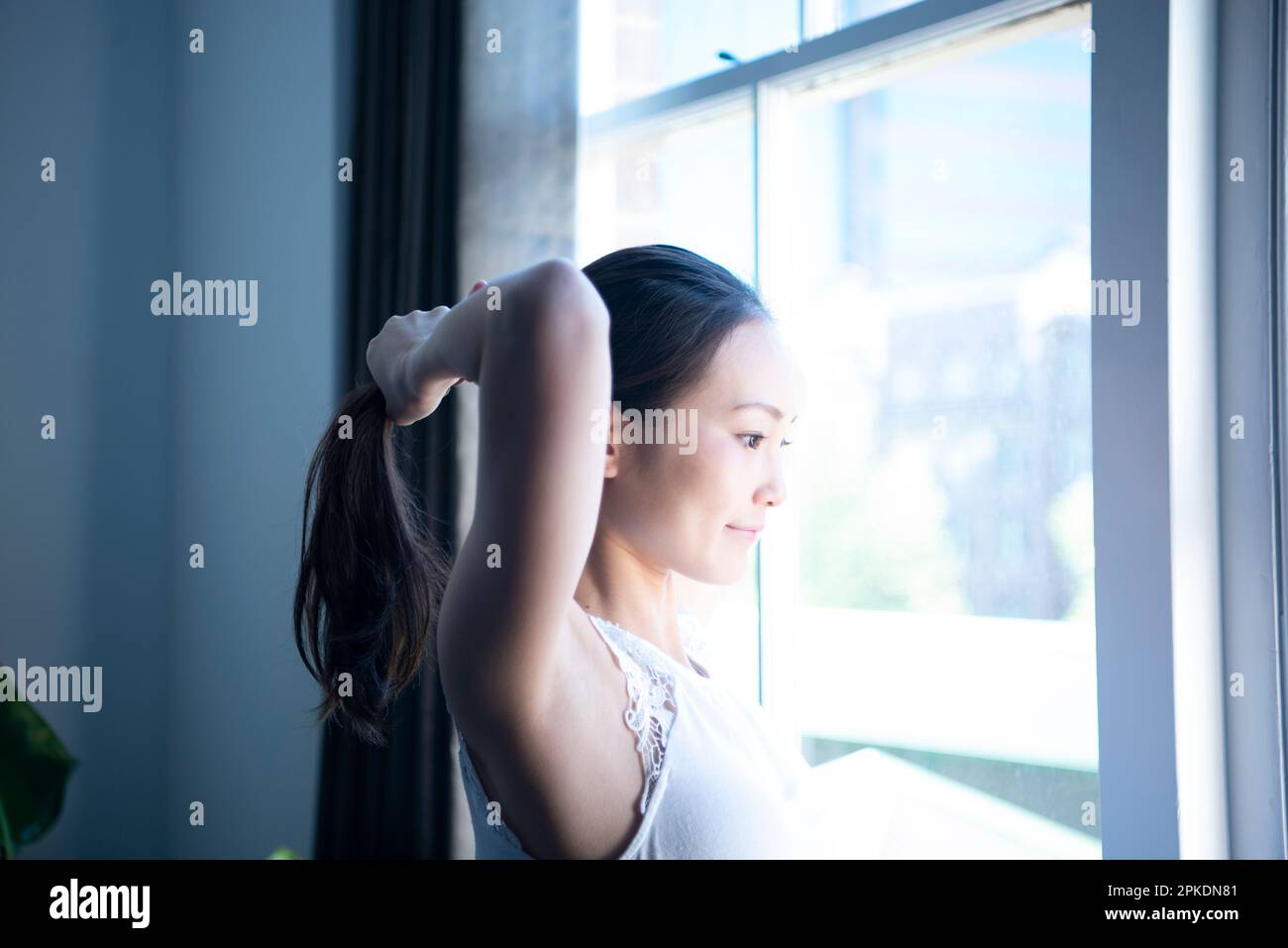 Woman tying her hair Stock Photo - Alamy