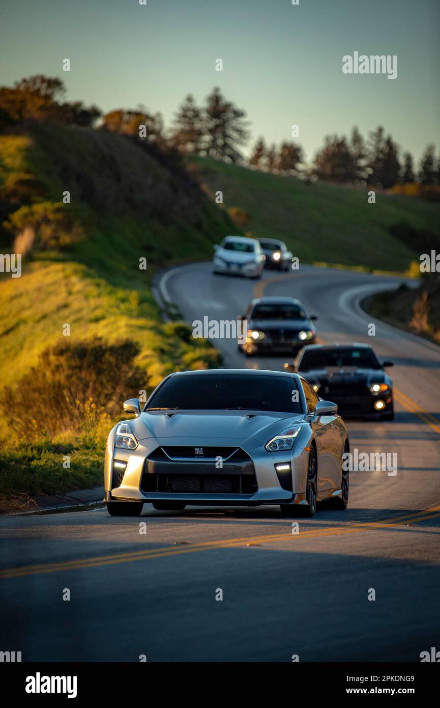 A row of cars driving on a road Stock Photo - Alamy