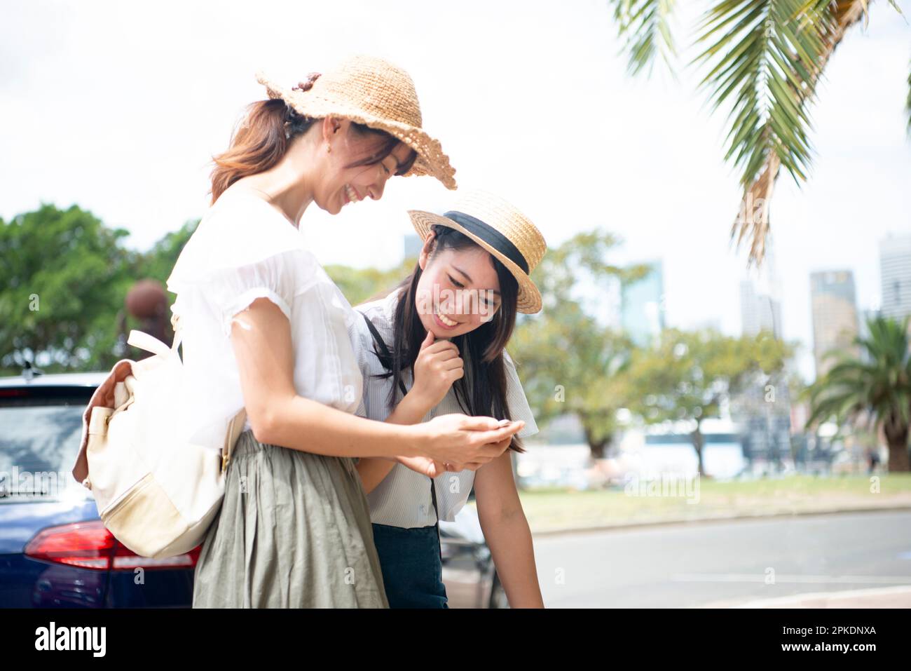 Two women laughing while looking at their phones Stock Photo - Alamy