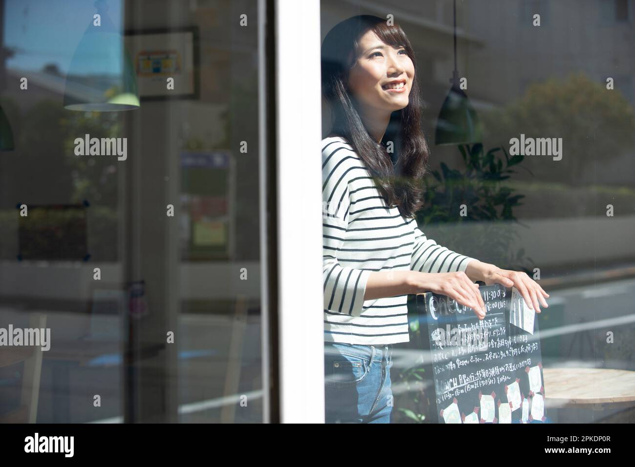 Woman laughing with sign in store Stock Photo - Alamy