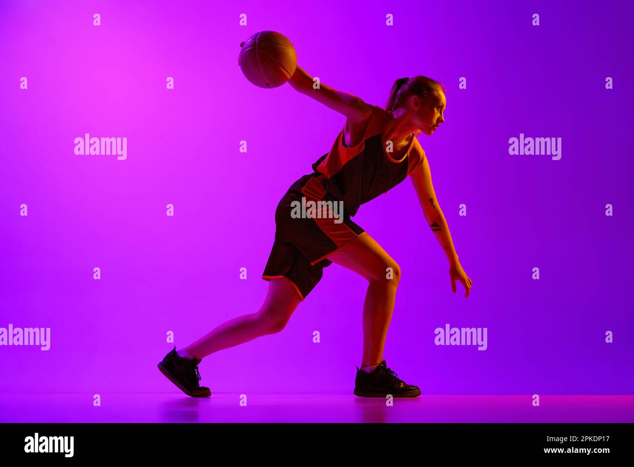 Young girl, concentrated female basketball player in motion, dribbling ...